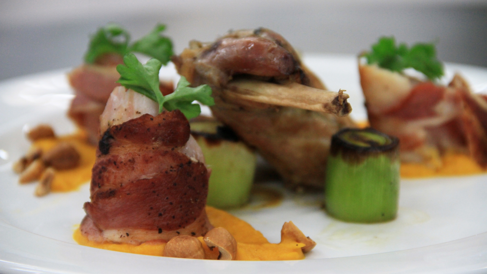 Rabbit legs braised in cider, bacon wrapped loin, carrot puree and leeks